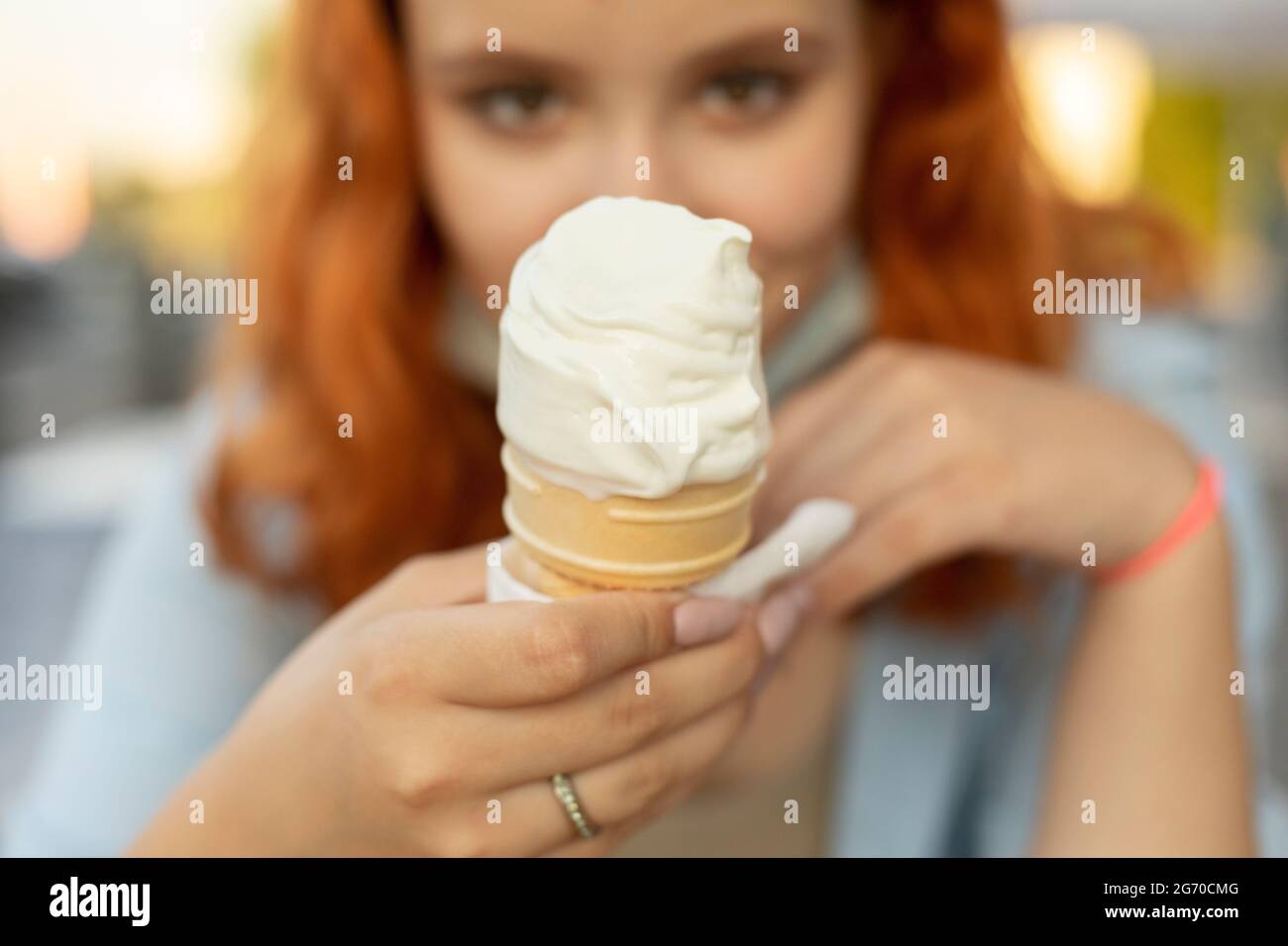 The girl holds ice cream in her hand. Creamy ice cream in a waffle cup ...