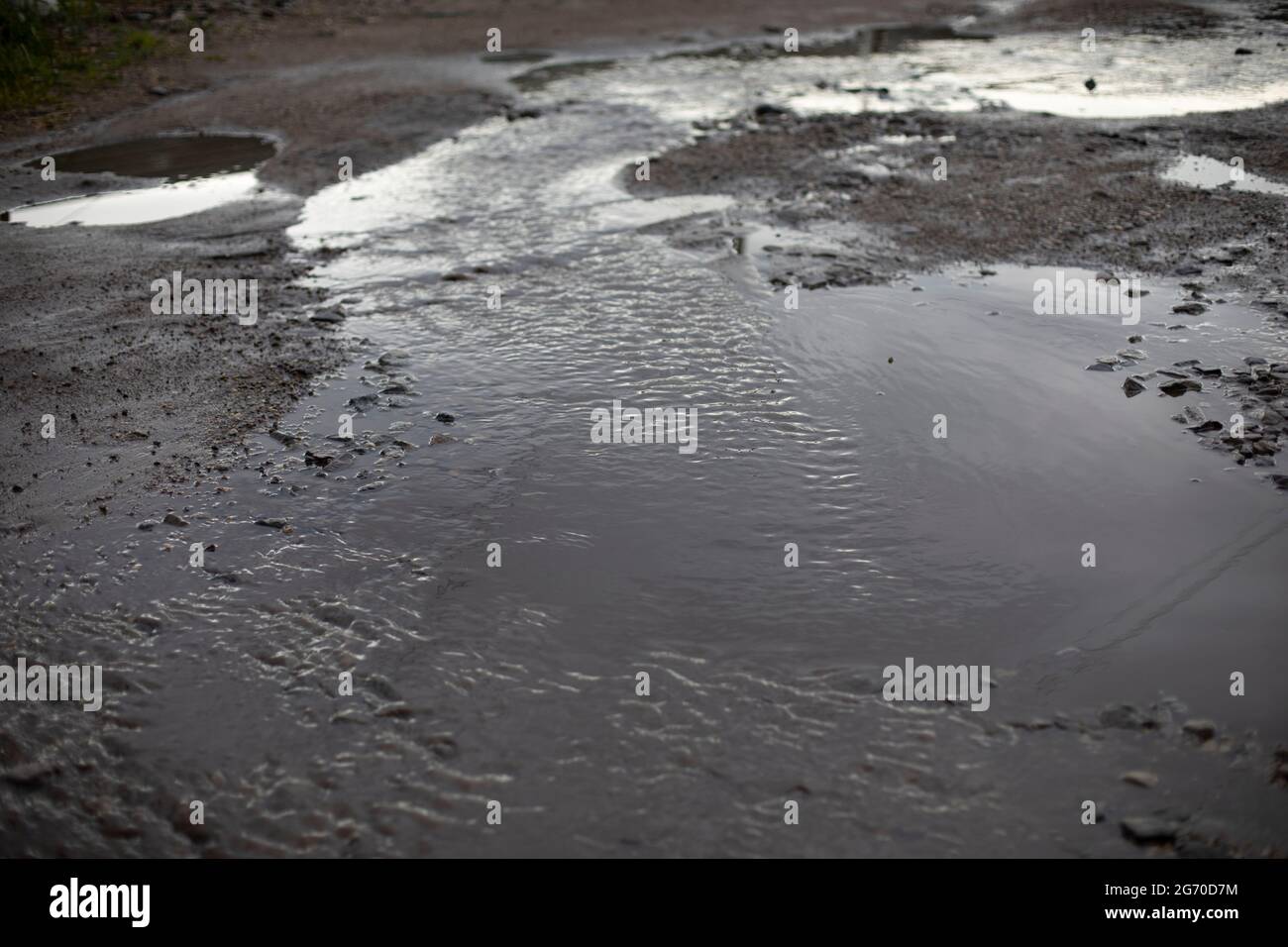 Dirty puddle on the road. Drain the water on the roadway. Flooding of ...