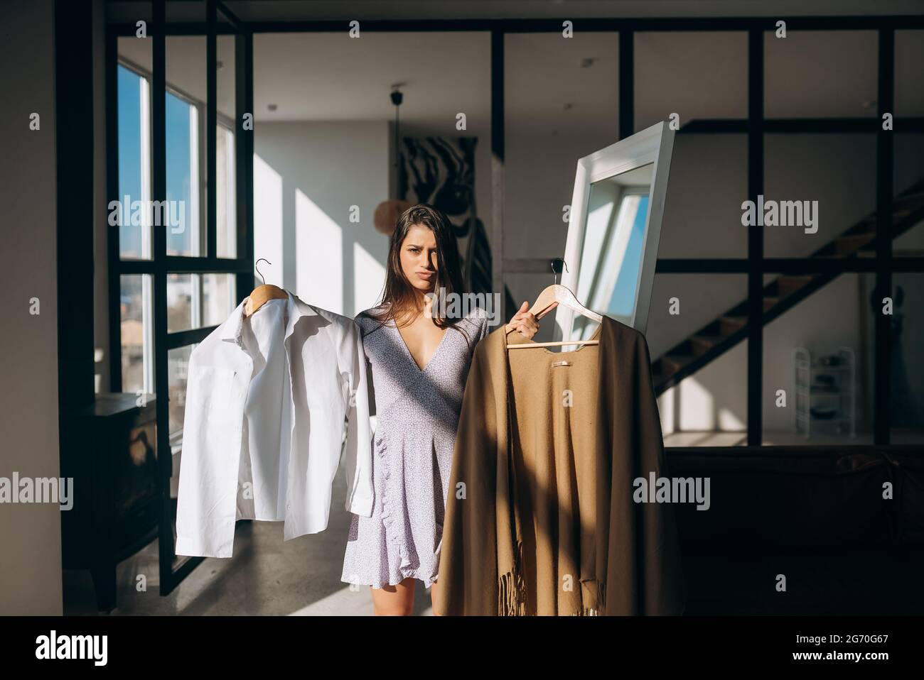Beautiful girl trying dress in room Stock Photo - Alamy
