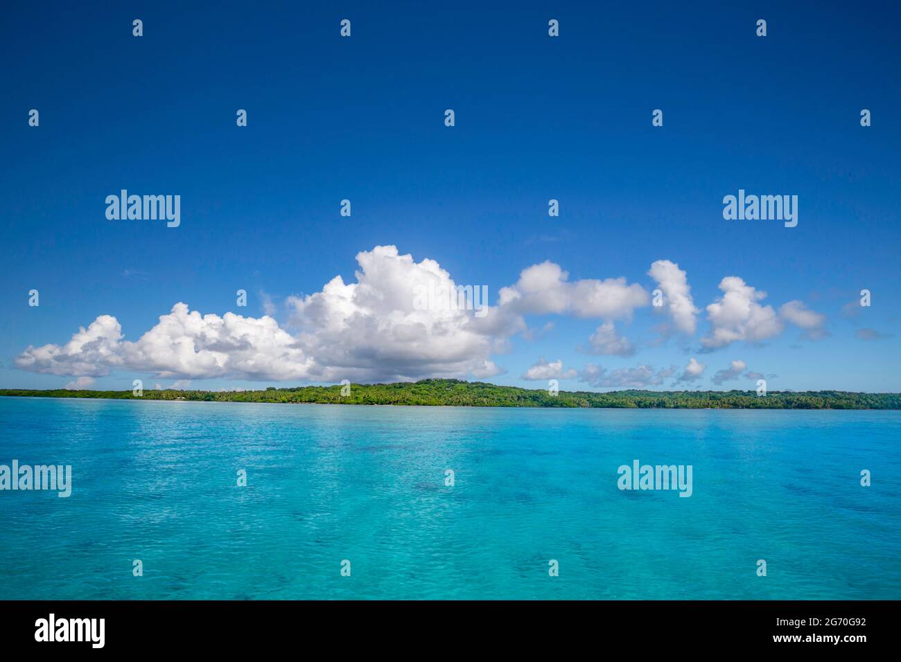An idyllic tropical view of the shallow lagoon with mid-day clouds over ...