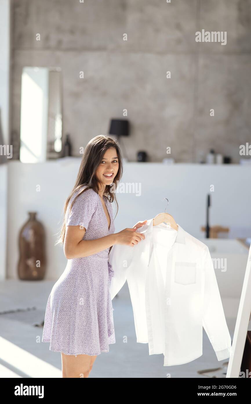 Beautiful girl trying dress in room Stock Photo - Alamy