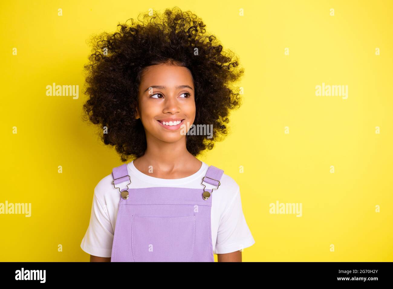 Portrait of optimistic cute curly girl wear white t-shirt look empty ...