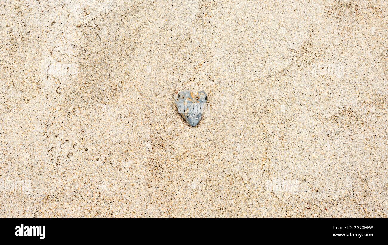 Heart-shaped gray sea rock on sandy beach Stock Photo - Alamy