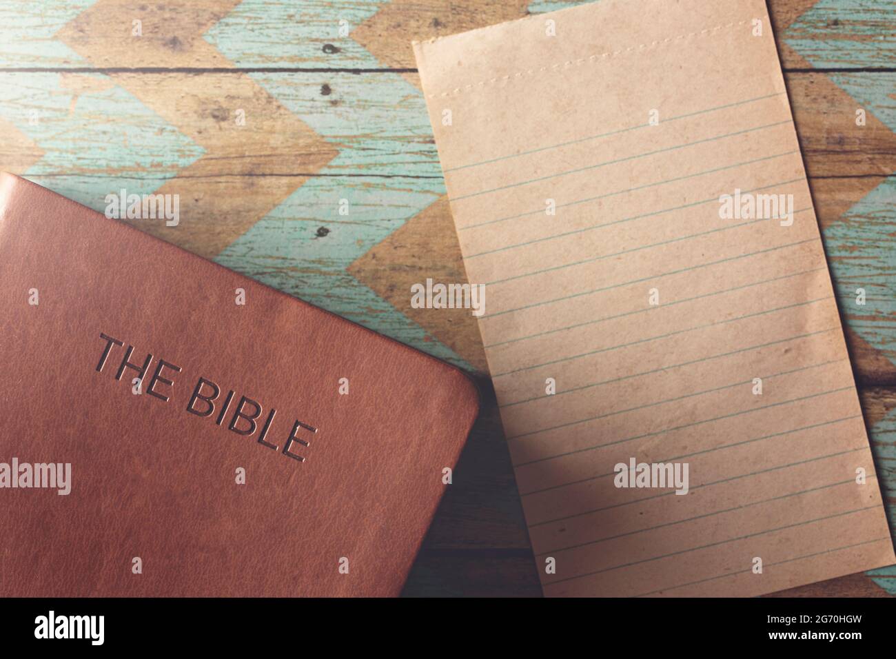 The Holy Bible on a Rustic Wooden Table with a Blank Piece of Antique ...