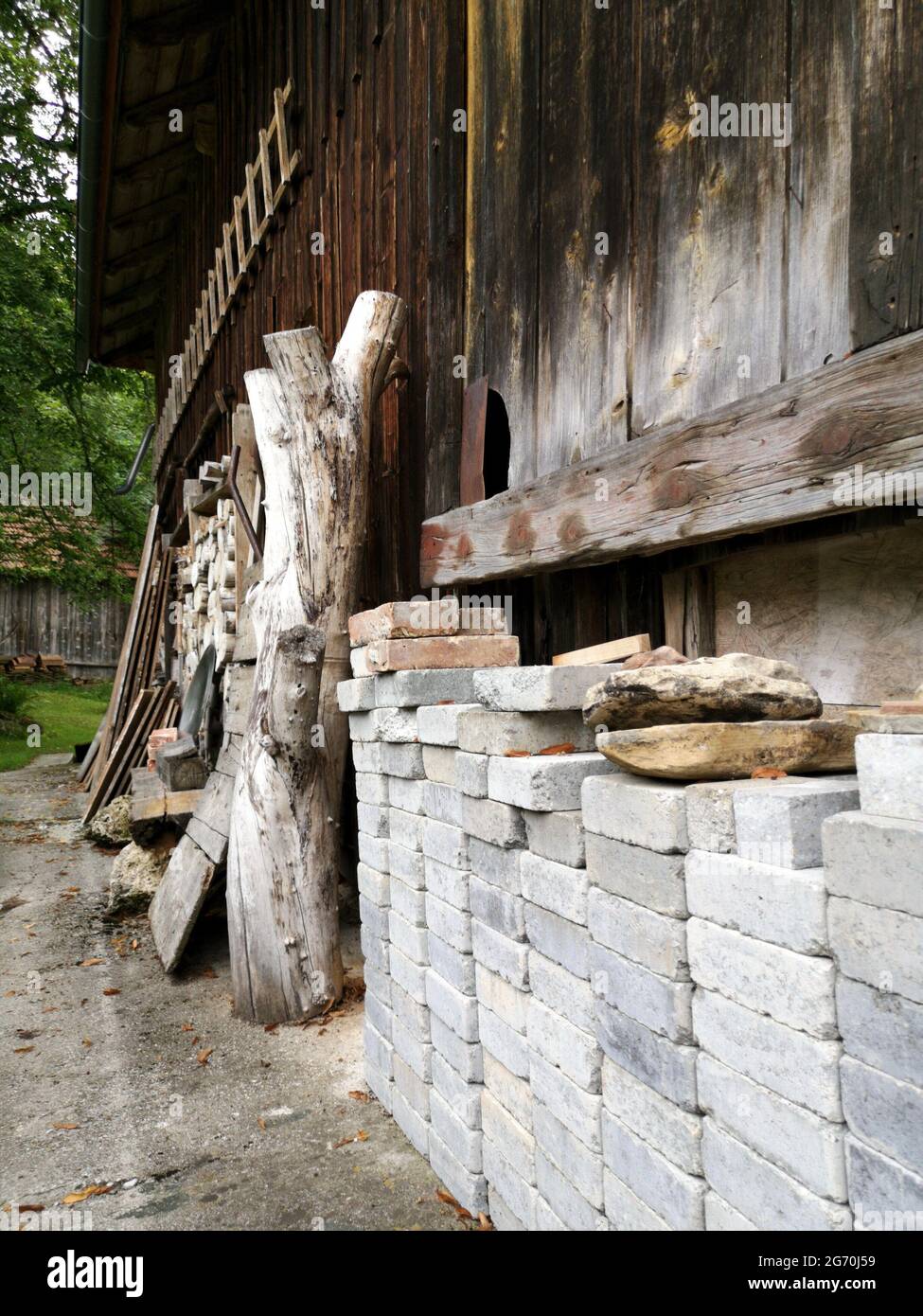 Vertical image of a wooden wall with a stair hanging on it, bricks, and ...