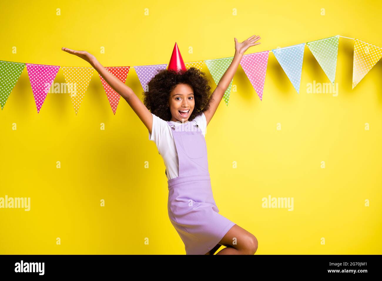 Photo of little girl raise arms celebrate open mouth wear cone headwear ...