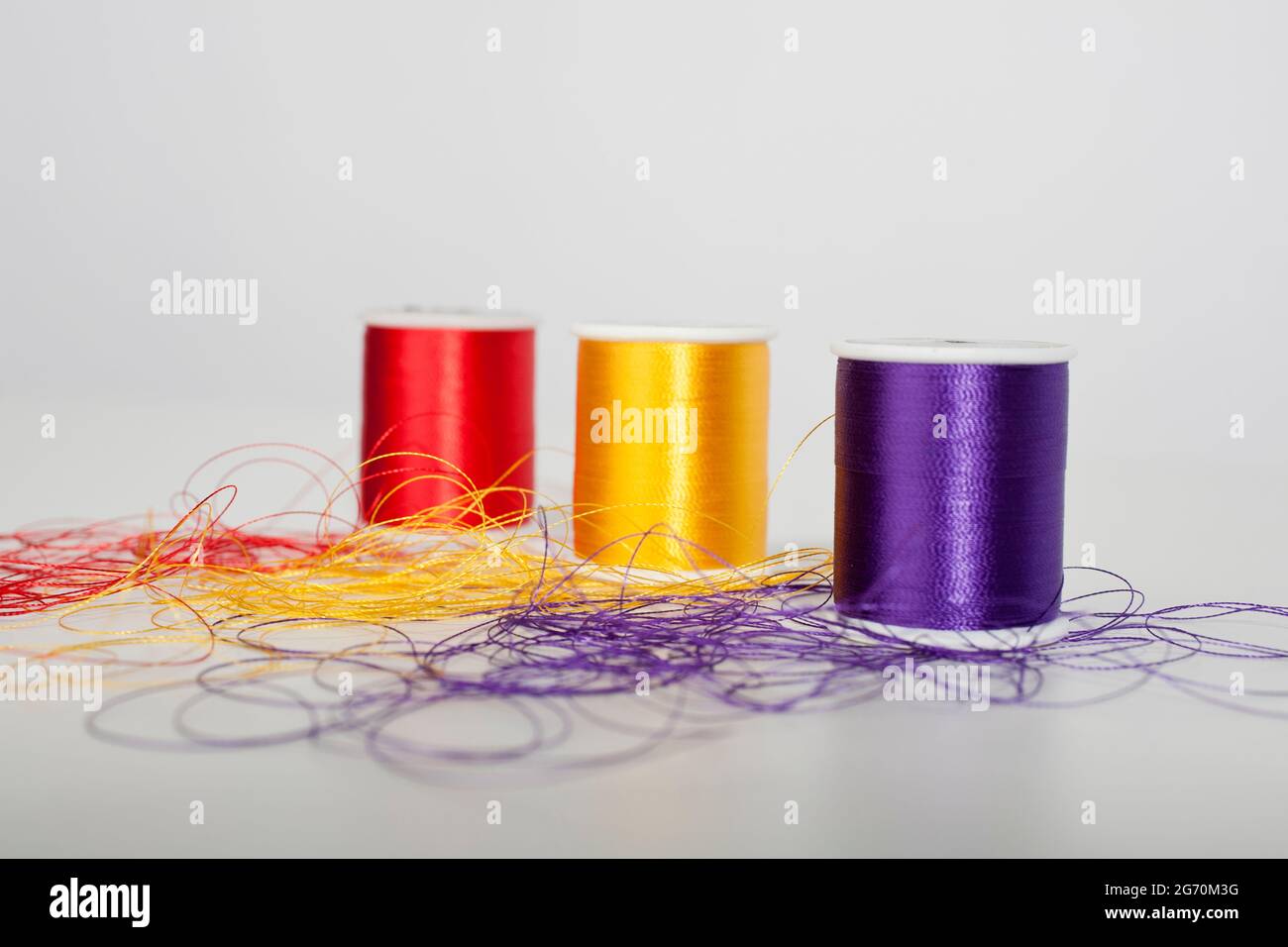 colorful thread on a white background Stock Photo - Alamy
