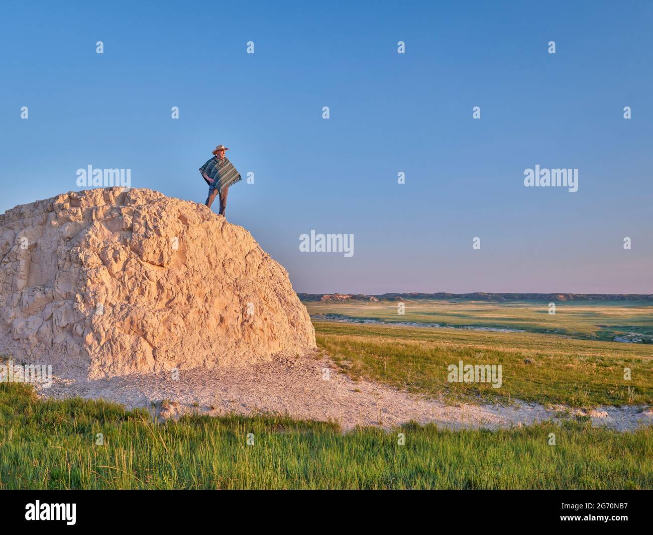 Man in a Mexican poncho and cowboy hat is enjoying summer sunrise at ...
