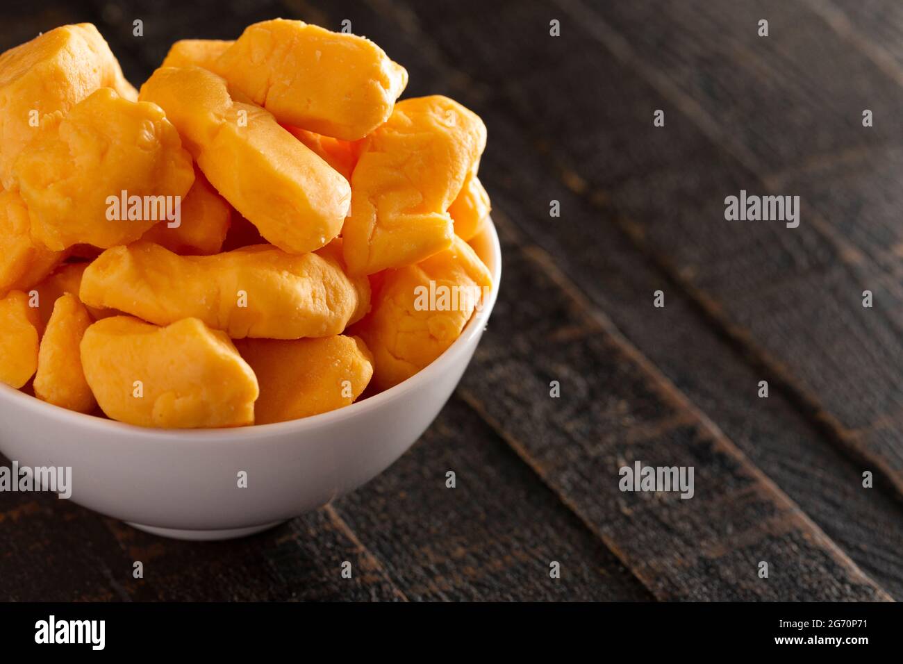 A Bowl of Cheddar Cheese Curds on a Rustic Wooden Table Stock Photo - Alamy
