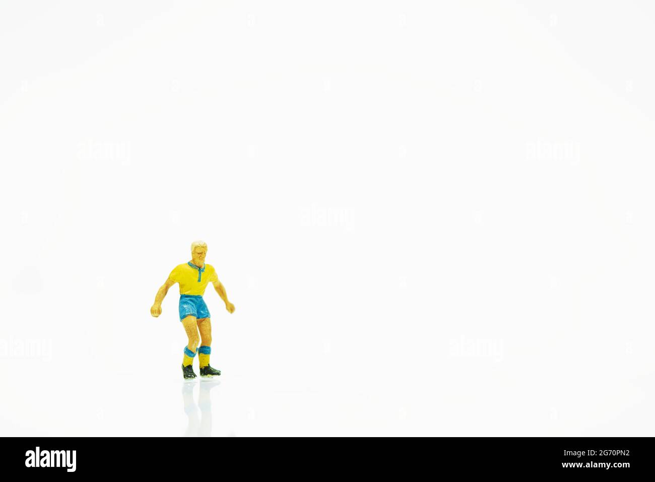 Isolated small figure of male football player wearing sportive uniform ...