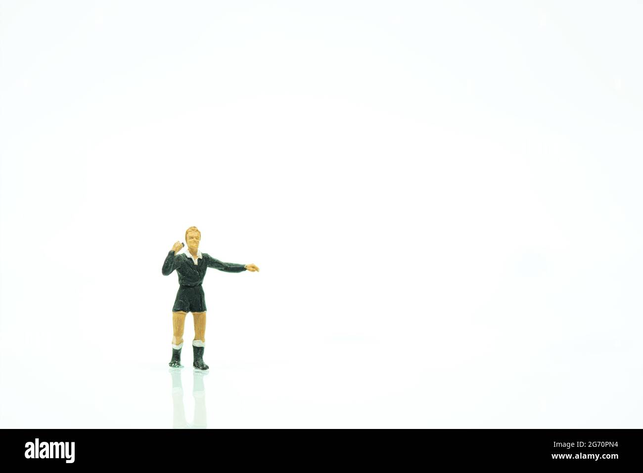 Isolated small figure of male football referee wearing black uniform ...