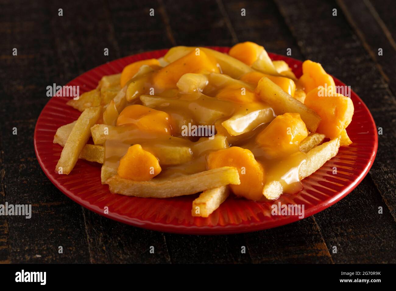 Poutine with Orange Cheddar Cheese with Brown Gravy on French Fries ...
