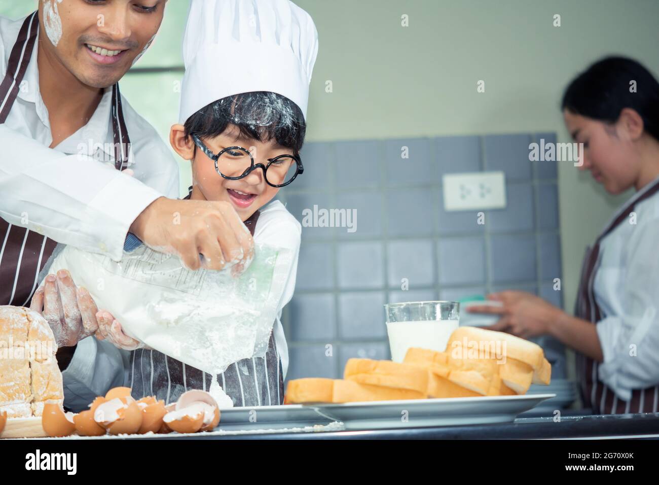Asian Boy wear glasses Tease dad cooking with white flour Kneading ...