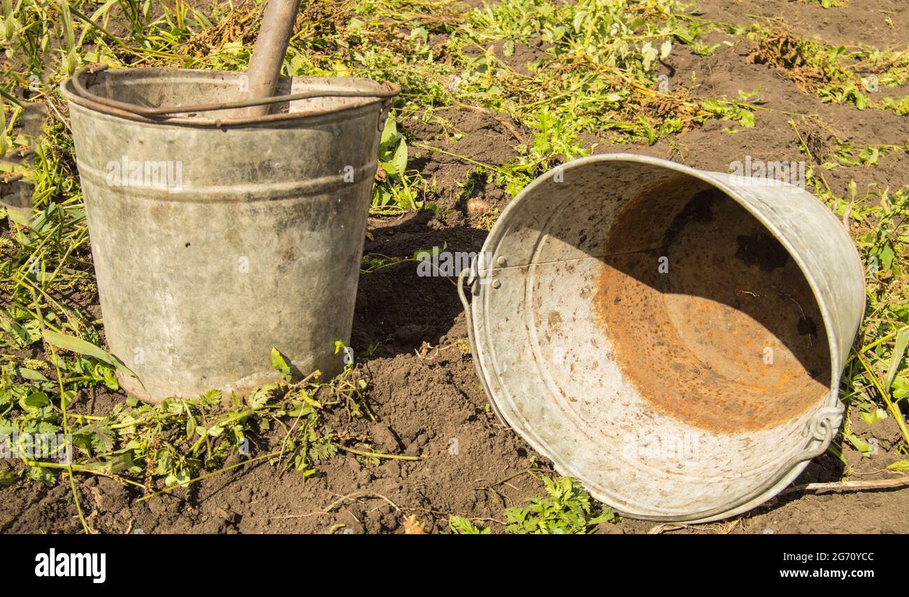 Two old, dirty, rusty, iron buckets with dirty inside and outside are ...