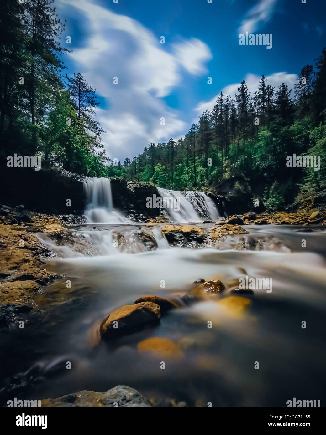 Waterfall with rocky and foamy water in a dense forest Stock Photo - Alamy