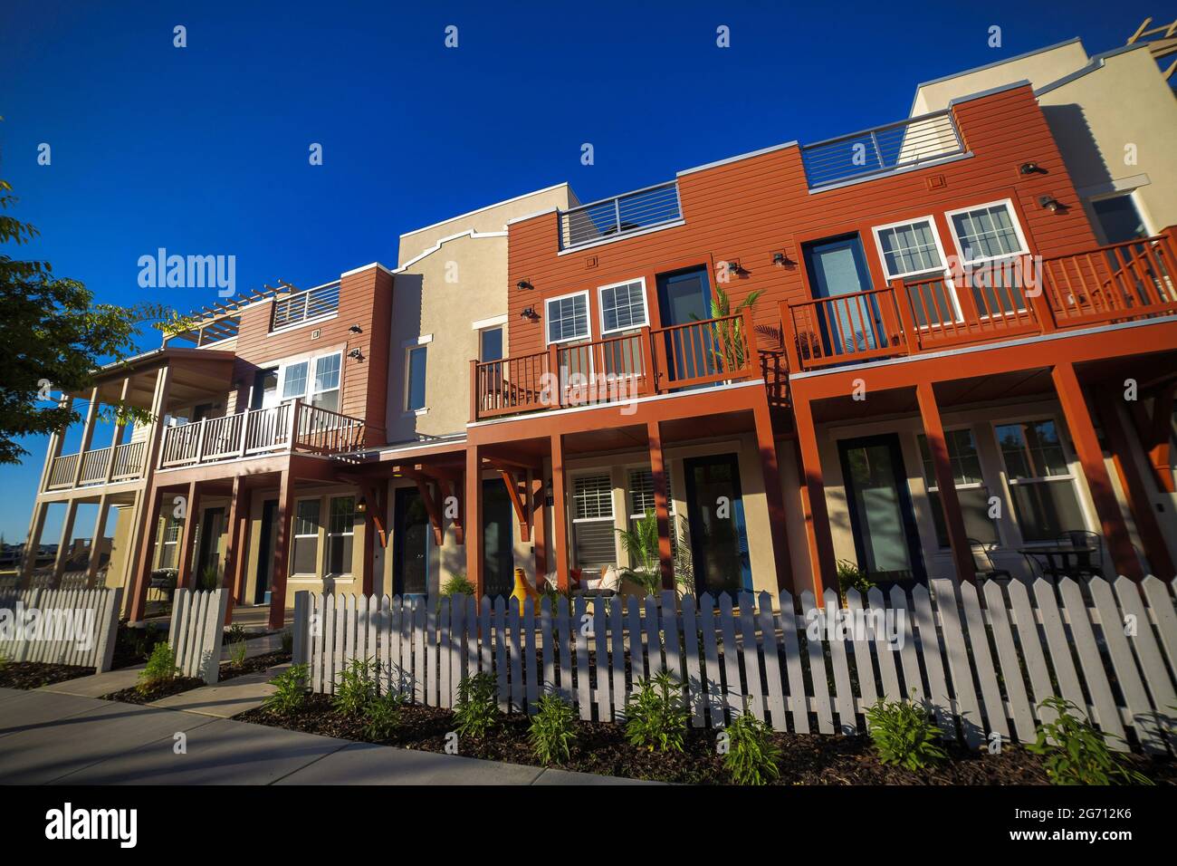 Low angle view of modern houses with yards and open roofs for rest, and ...