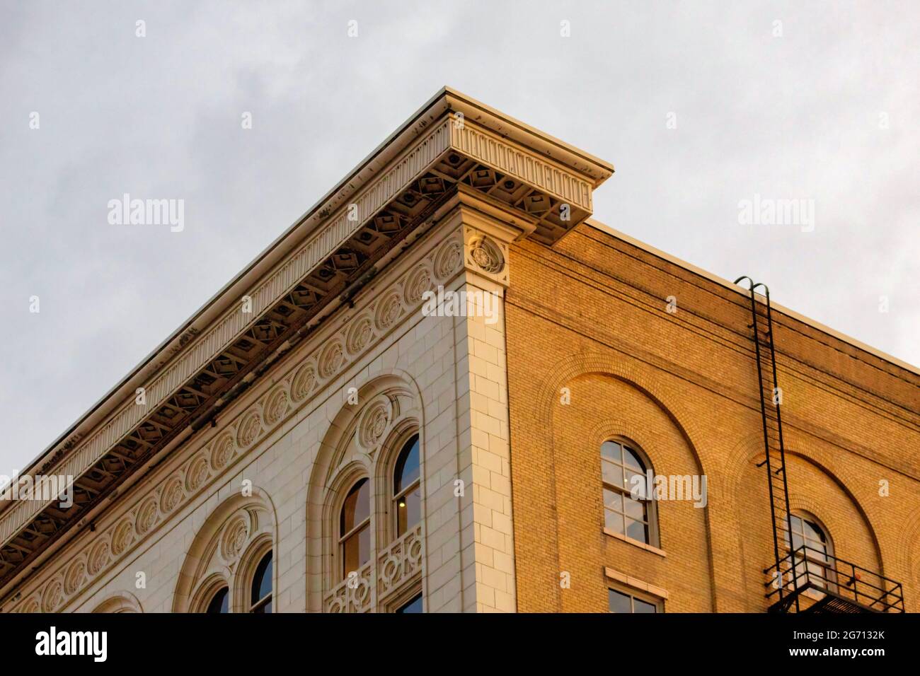 Low angle view a brown and white stone building with stairs to the roof ...