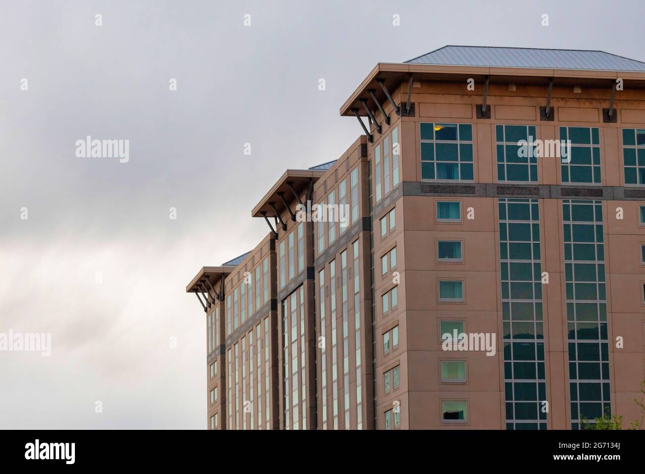 View of a brown building with long windows on a cloudy day Stock Photo ...