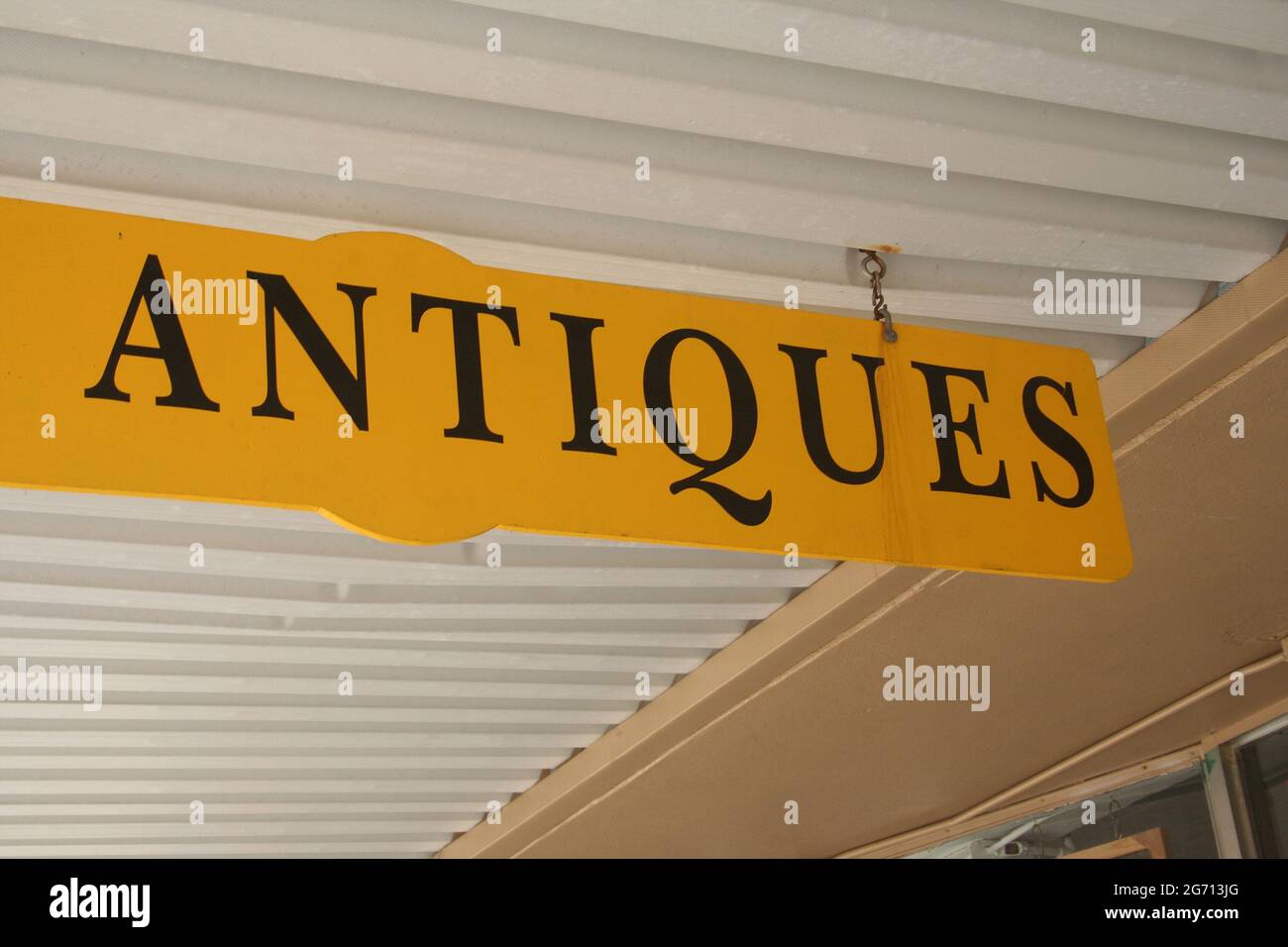 Sign hanging from the roof in front of an antiques shop in downtown ...