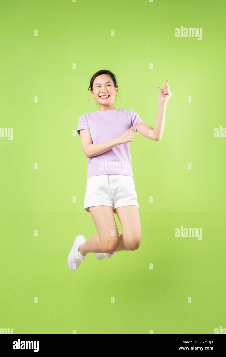 Full body Young Asian girl jumping, isolated on green background Stock ...