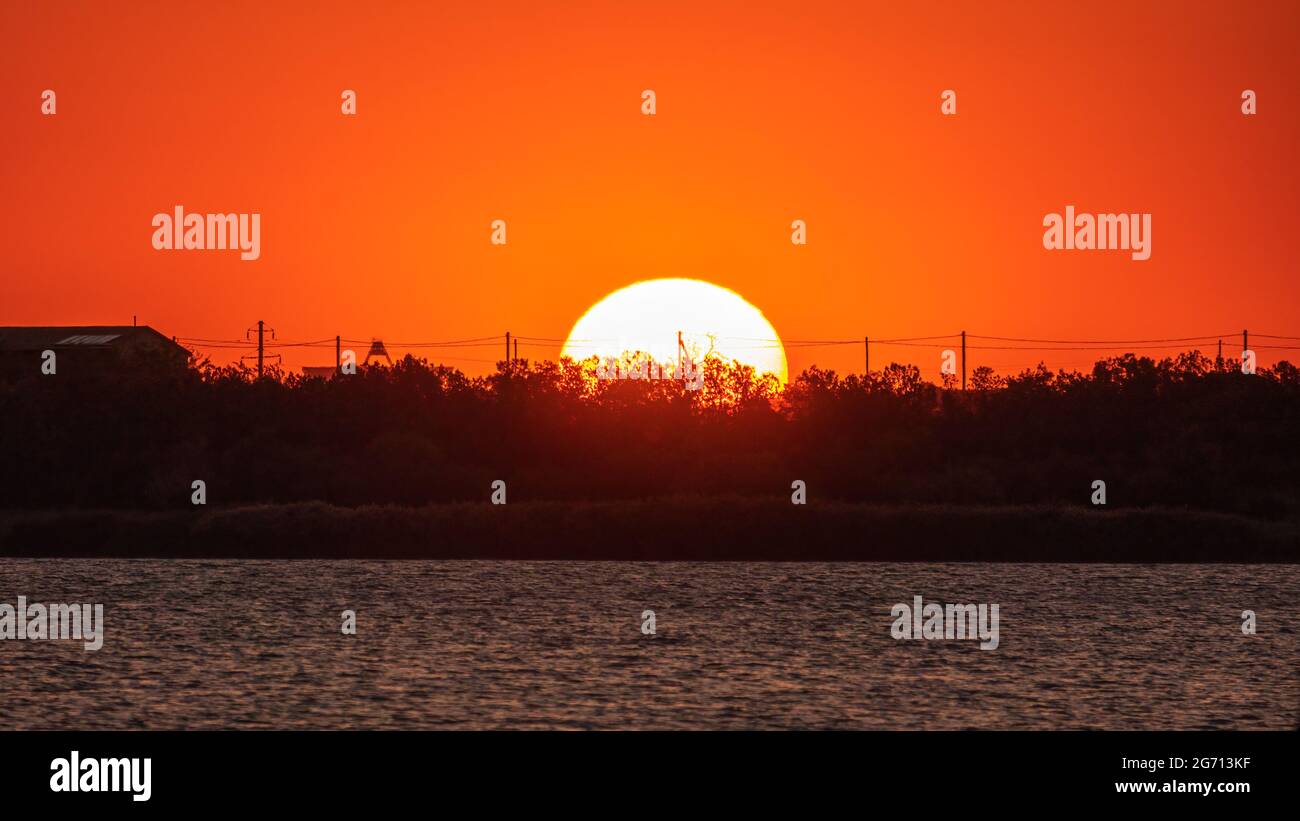 The sun goes down over a lake. Dramatic Sunset Sky Stock Photo - Alamy