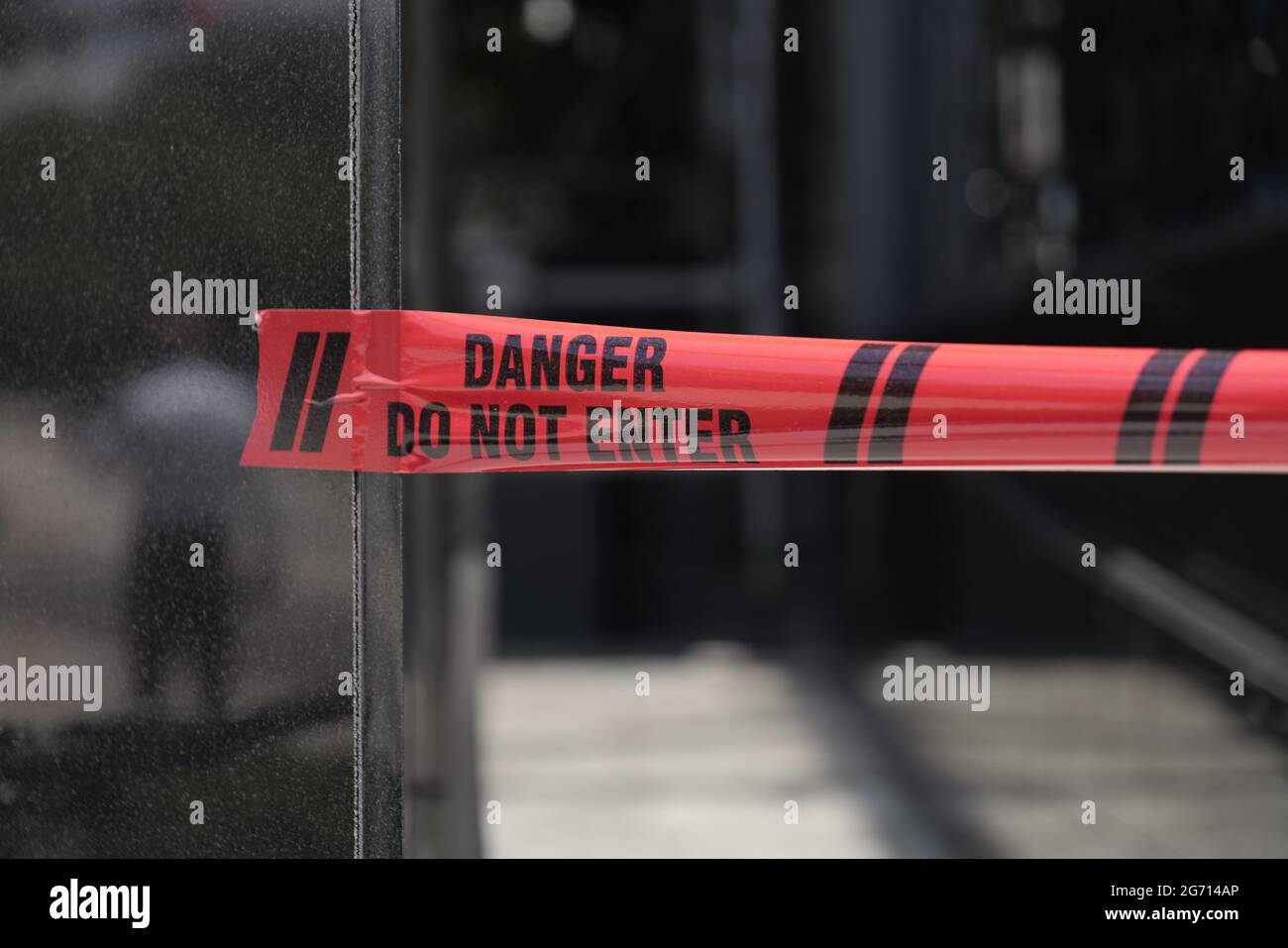 Selective focus of a red safety tape with "DANGER DO NOT ENTER" written ...