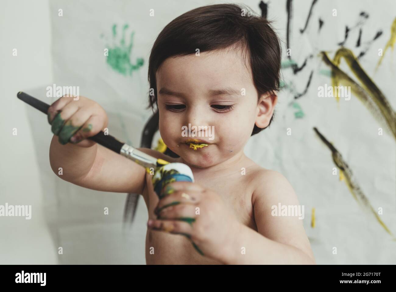 Shallow focus of a toddler trying to eat paint Stock Photo - Alamy