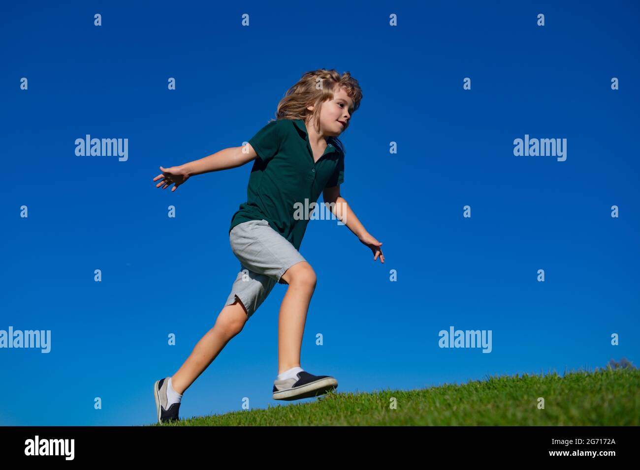 Child boy running on grass field and dreaming. Kids play on summer ...