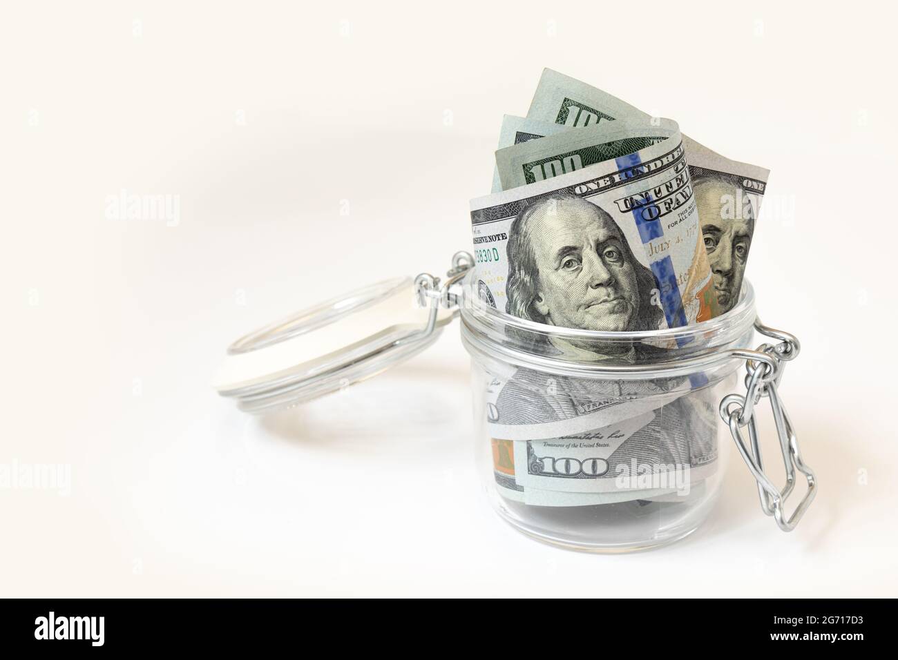 dollar banknote roll inside of saving jar isolated on white background ...