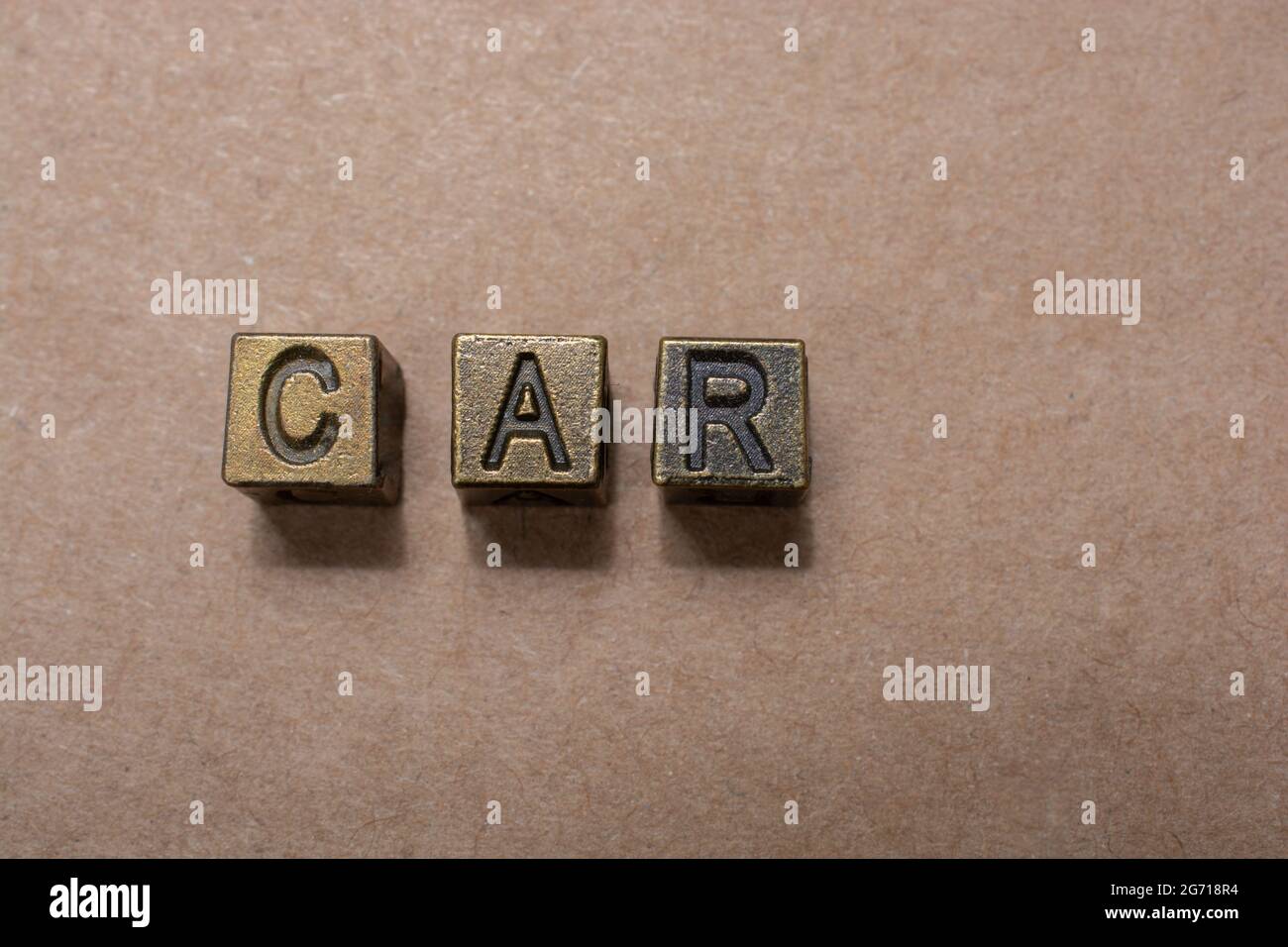 Top view of a word 'car' made with metal blocks isolated on a brown ...