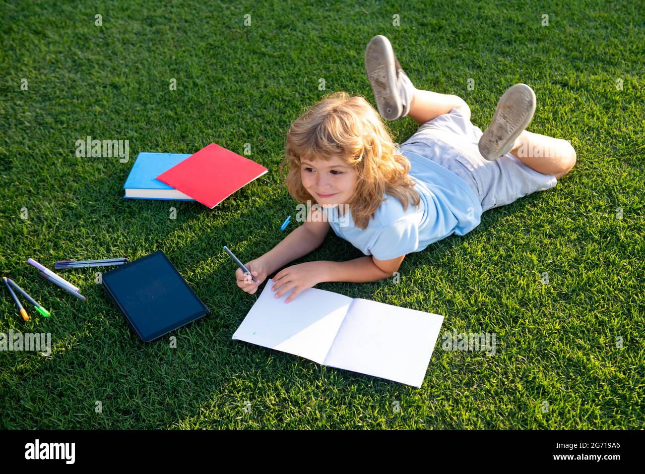 Child school writing on notebook, outdoor education. Nature and park ...
