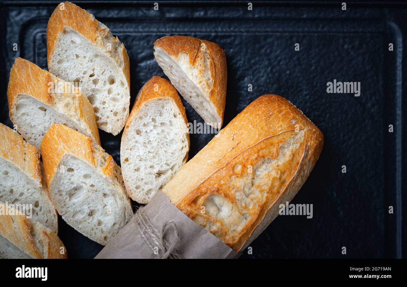 Sliced bread over dark stone table. View from above with copy space ...