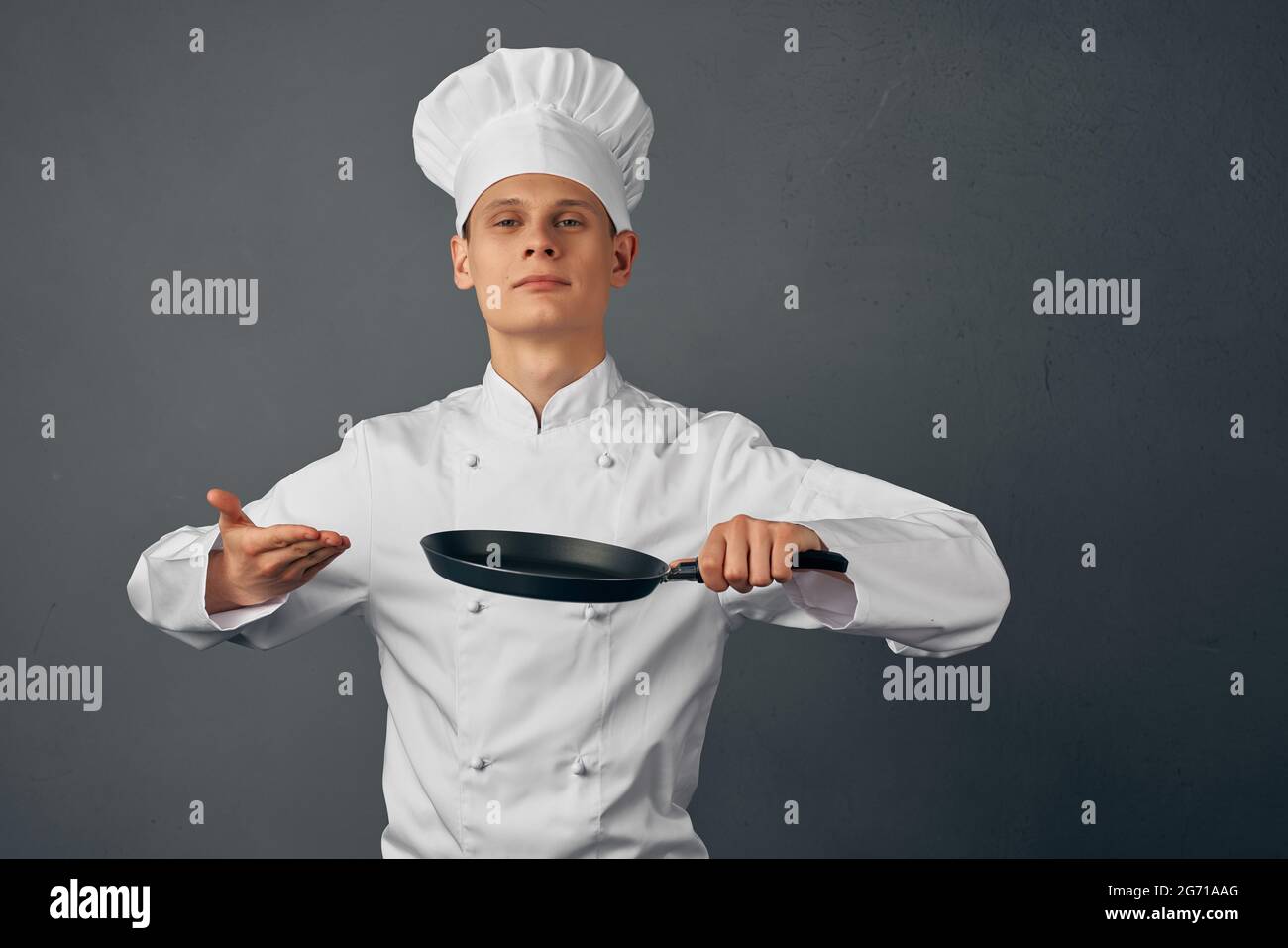 cafe on a cook's uniform a frying pan in hands cooking work in a ...