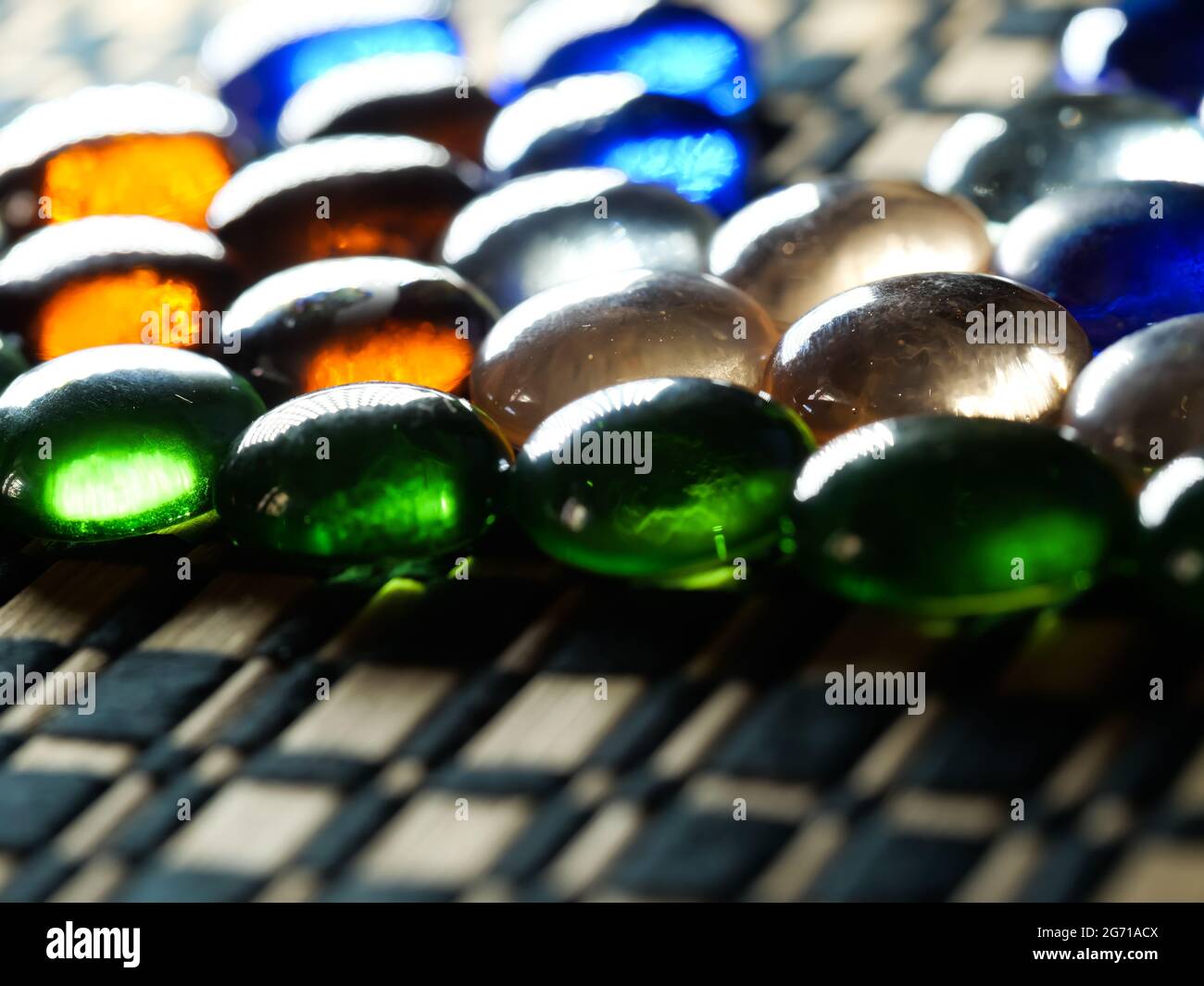 Closeup of colorful gleaming circular gems with lights shining on them ...