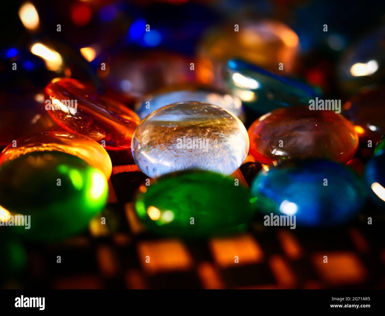 Closeup of fun vibrant glass gems reflecting bright lights on a ...
