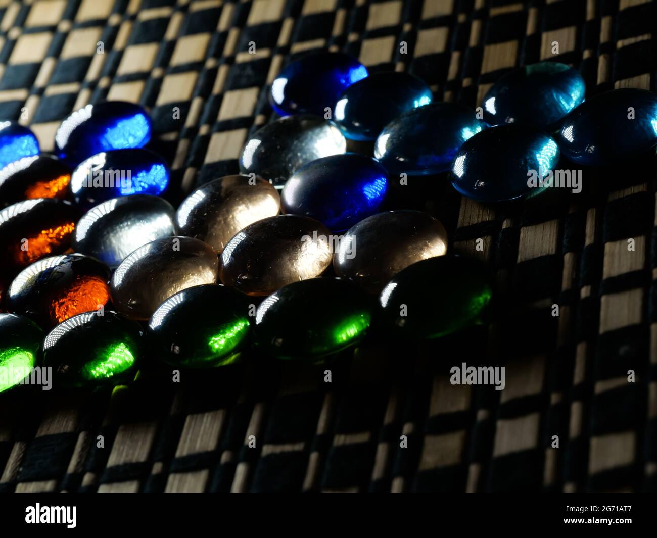 Closeup of symmetric circular board game tokens reflecting neon colors ...