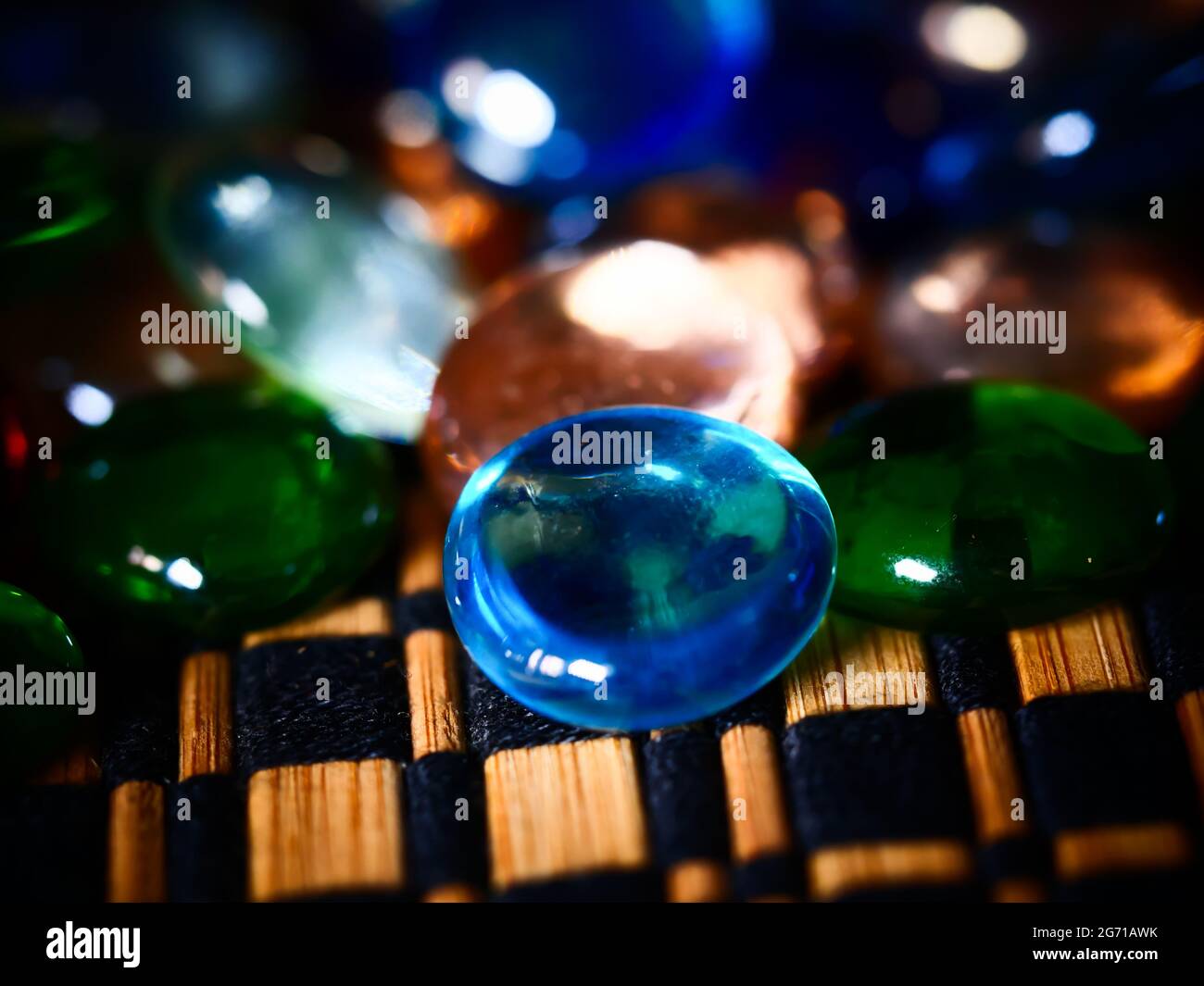 Closeup of a blue circular gem placed on a checkerboard with a blurry ...