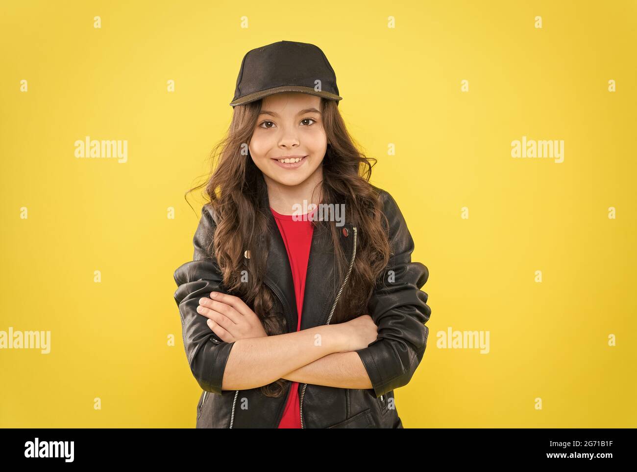 Happy small kid in casual style keep arms crossed with confident look ...