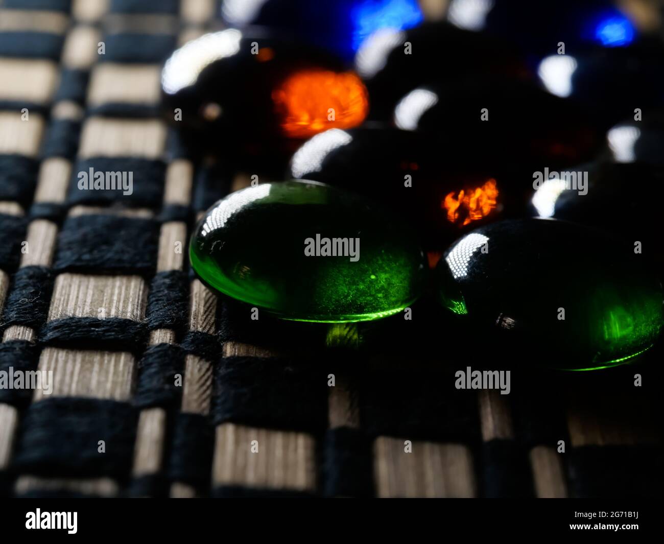 Closeup of colorful glass board game tokens with lights reflecting on ...