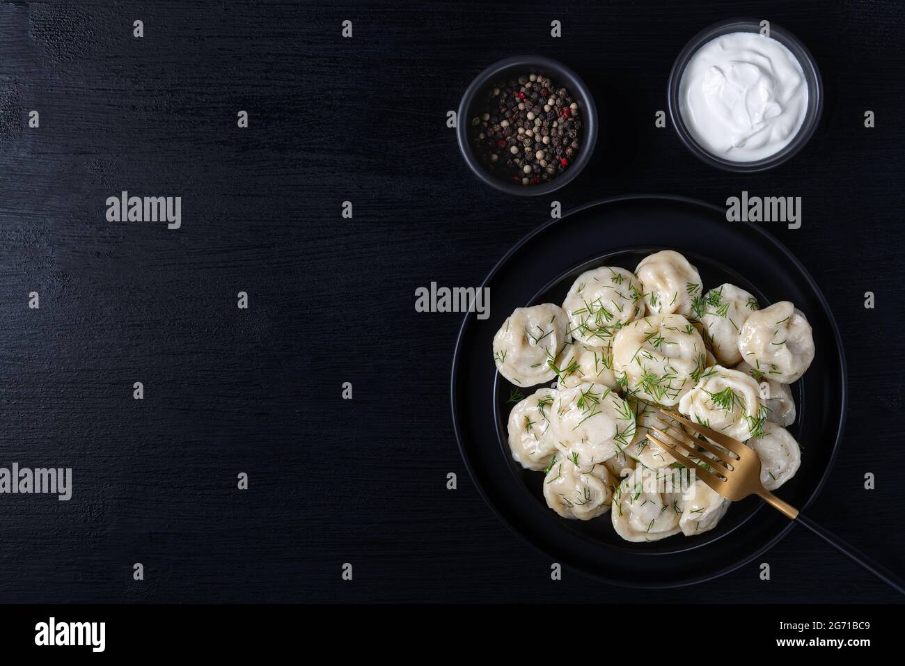 Traditional russian pelmeni, ravioli, dumplings with meat on black ...
