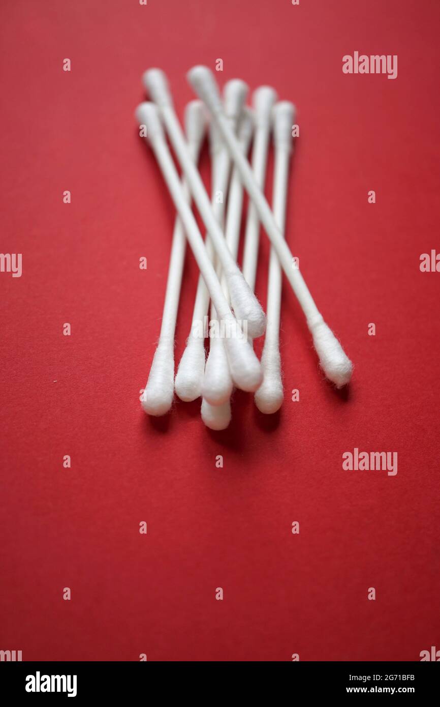 Vertical shot of ear sticks on a red background Stock Photo - Alamy
