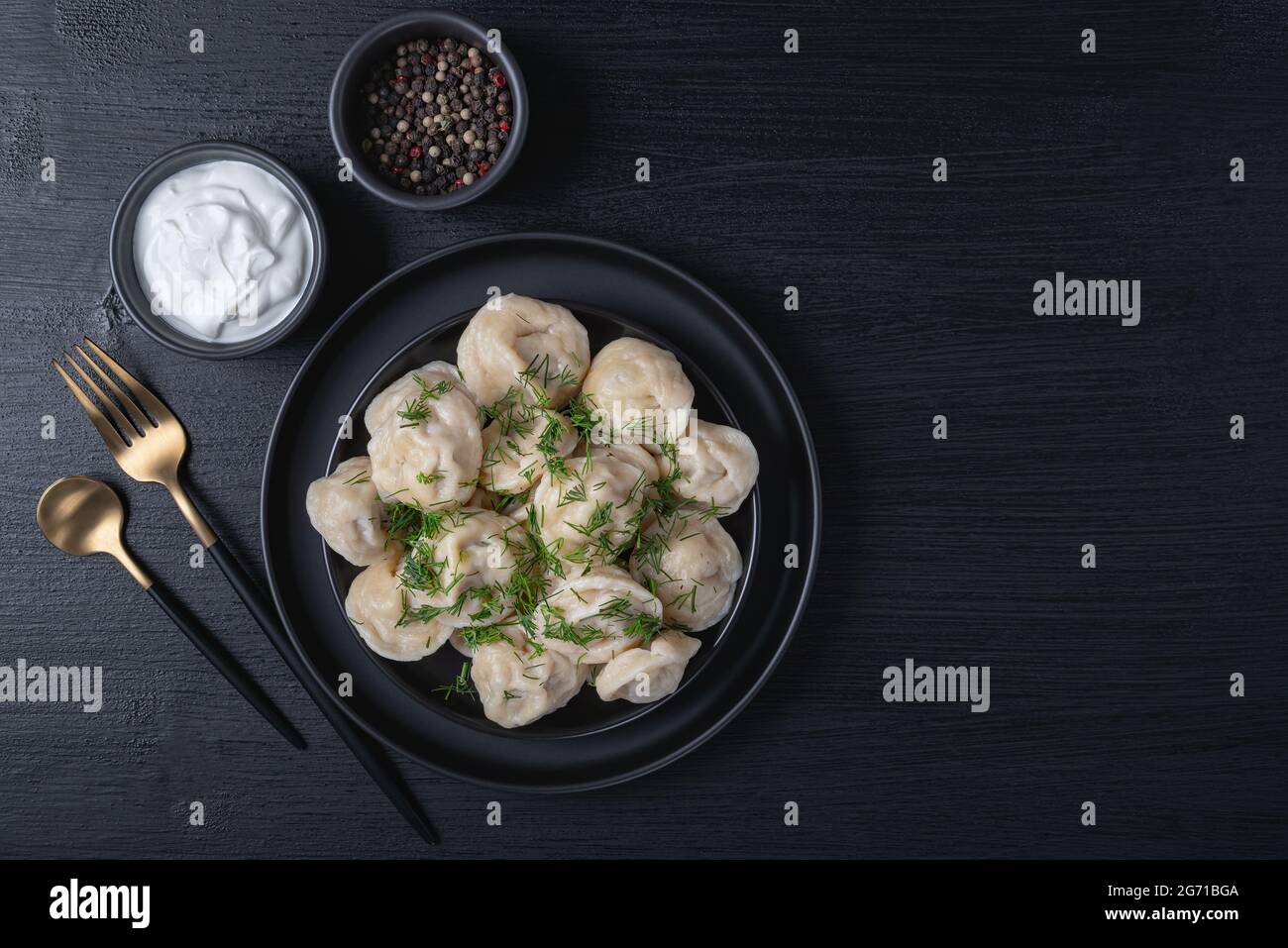 Traditional russian pelmeni, ravioli, dumplings with meat on black ...