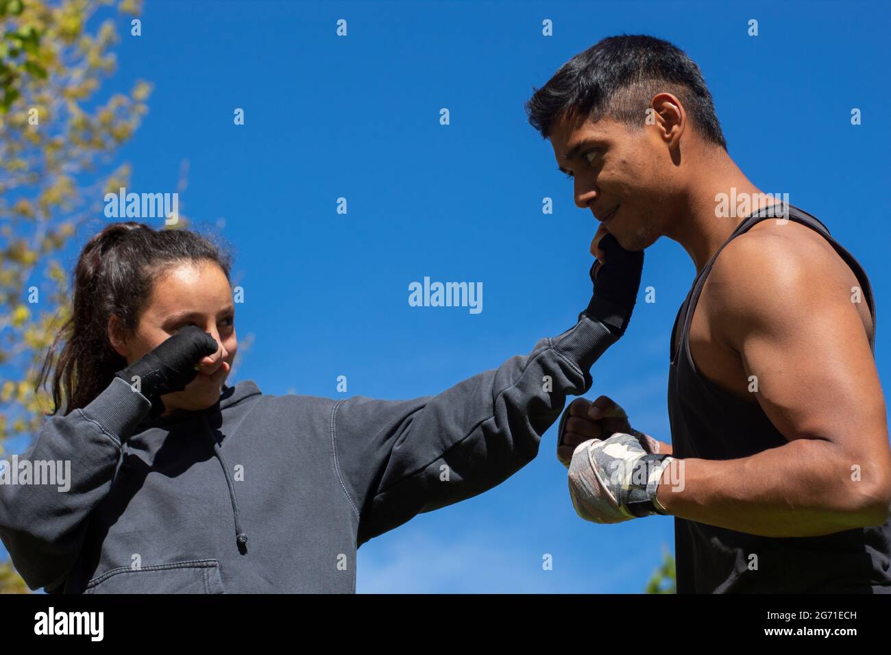 Female boxer training for a fight with her personal Hispan trainer ...
