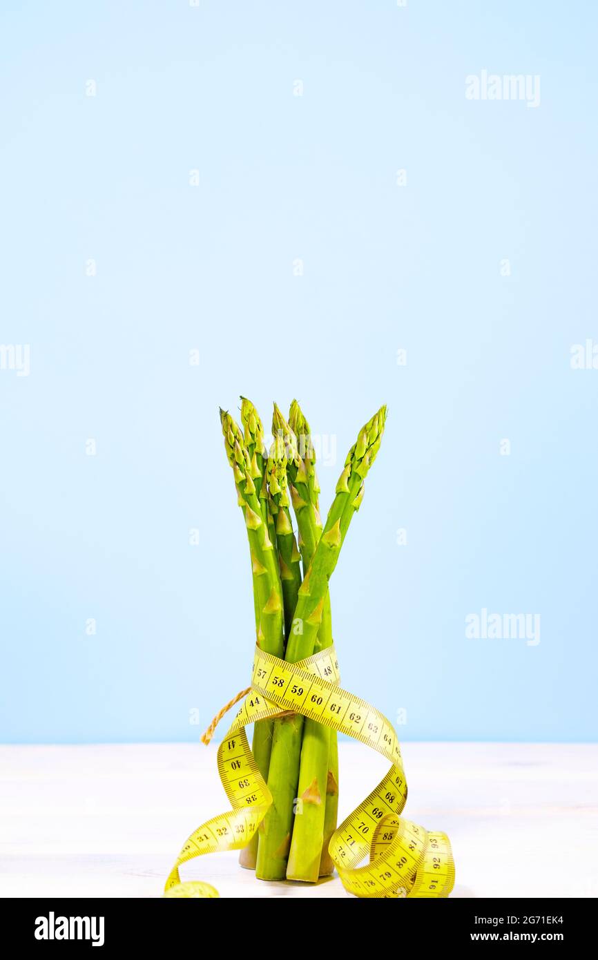 Raw asparagus and measuring type isolated on a blue background Stock ...