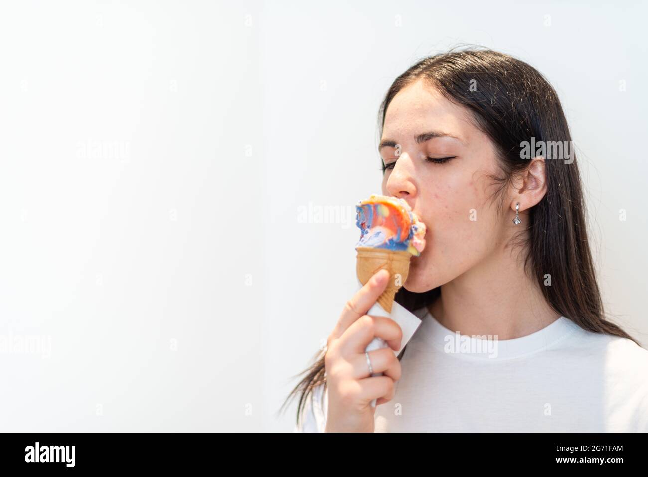 Young Caucasian female engrossed devouring cocktail Ice cream with ...