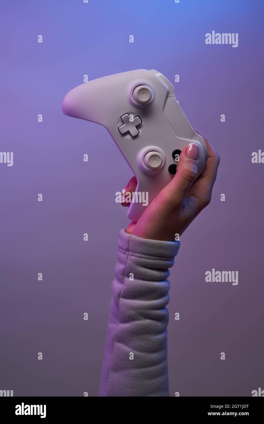 Hand with white game joystick on violet background. Gamer concept Stock ...