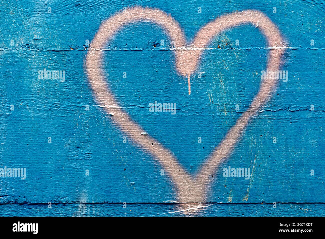 Heart outlined on a blue wall with light pink paint Stock Photo - Alamy