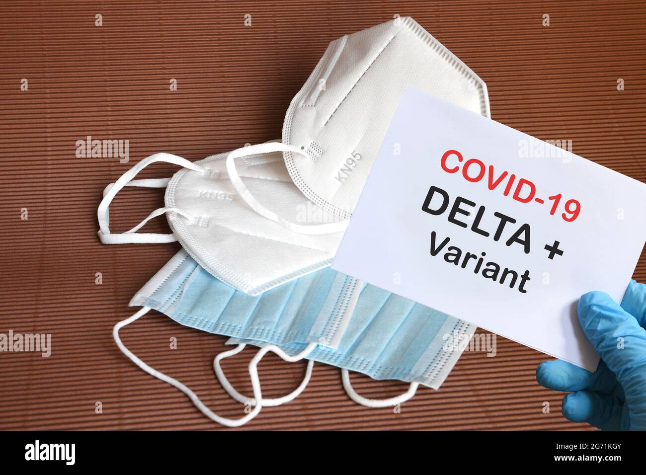 Doctor's hand in blue glove with white paper and text Covid-19 Delta ...