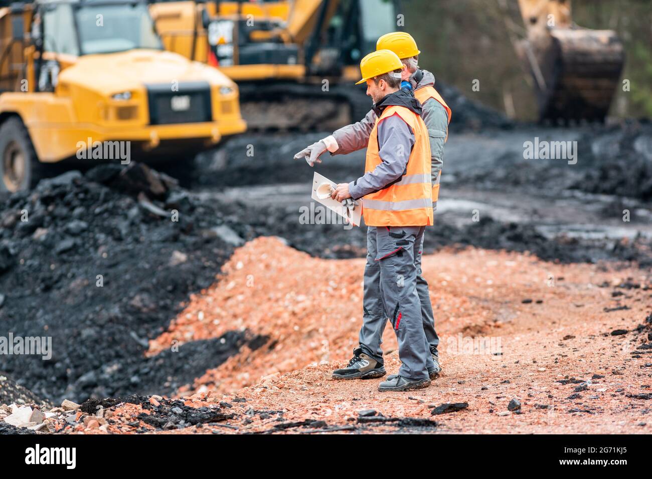 Two quarry workers discussing what to do next pointing at things Stock ...