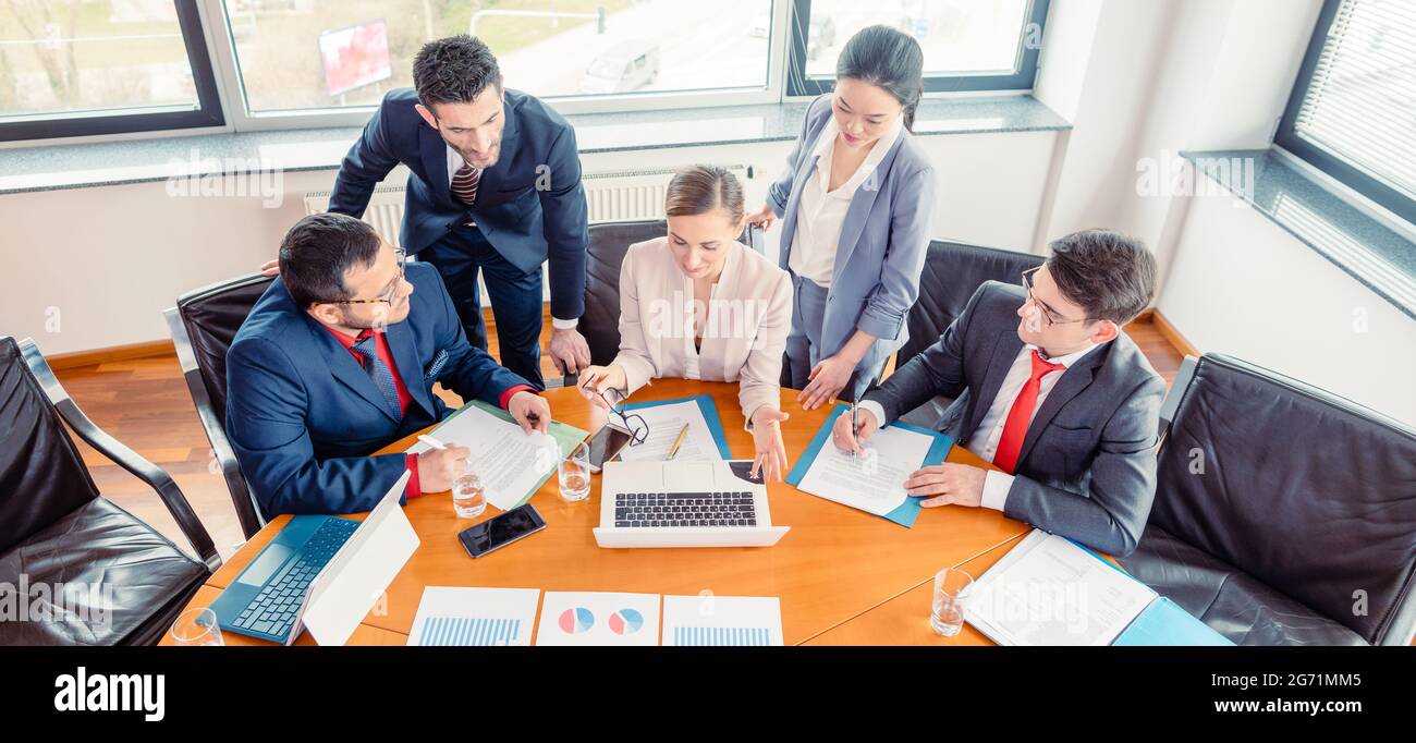 Five business people in a project meeting working together Stock Photo ...